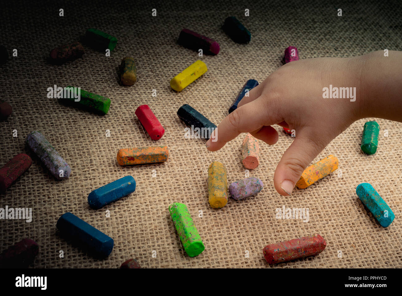 Used color crayons and a toddlers hand pointing Stock Photo - Alamy