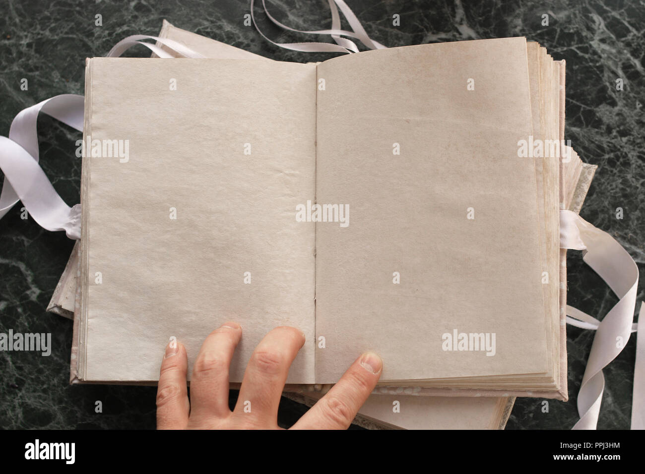 pages opened vintage book on green marble countertop Stock Photo - Alamy