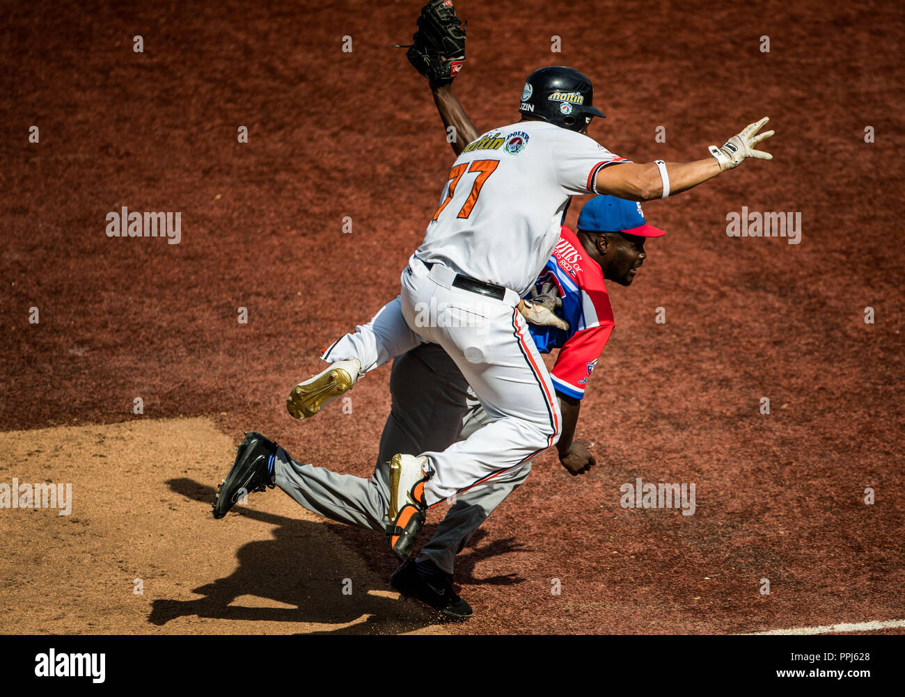 Rene Reyes de Venezuela choca con el pitcher David Richardson de Puerto ...
