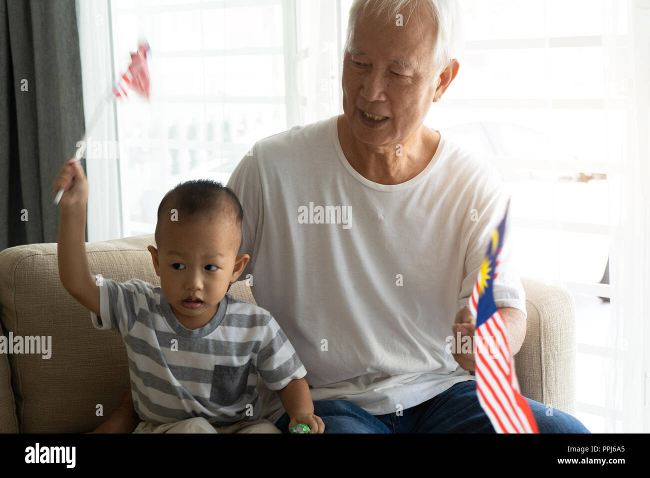 grandfather and gradson holding malaysia flag during national day Stock ...