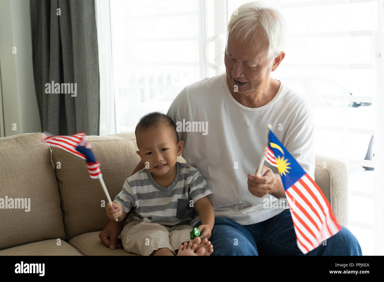 grandfather and gradson holding malaysia flag during national day Stock ...