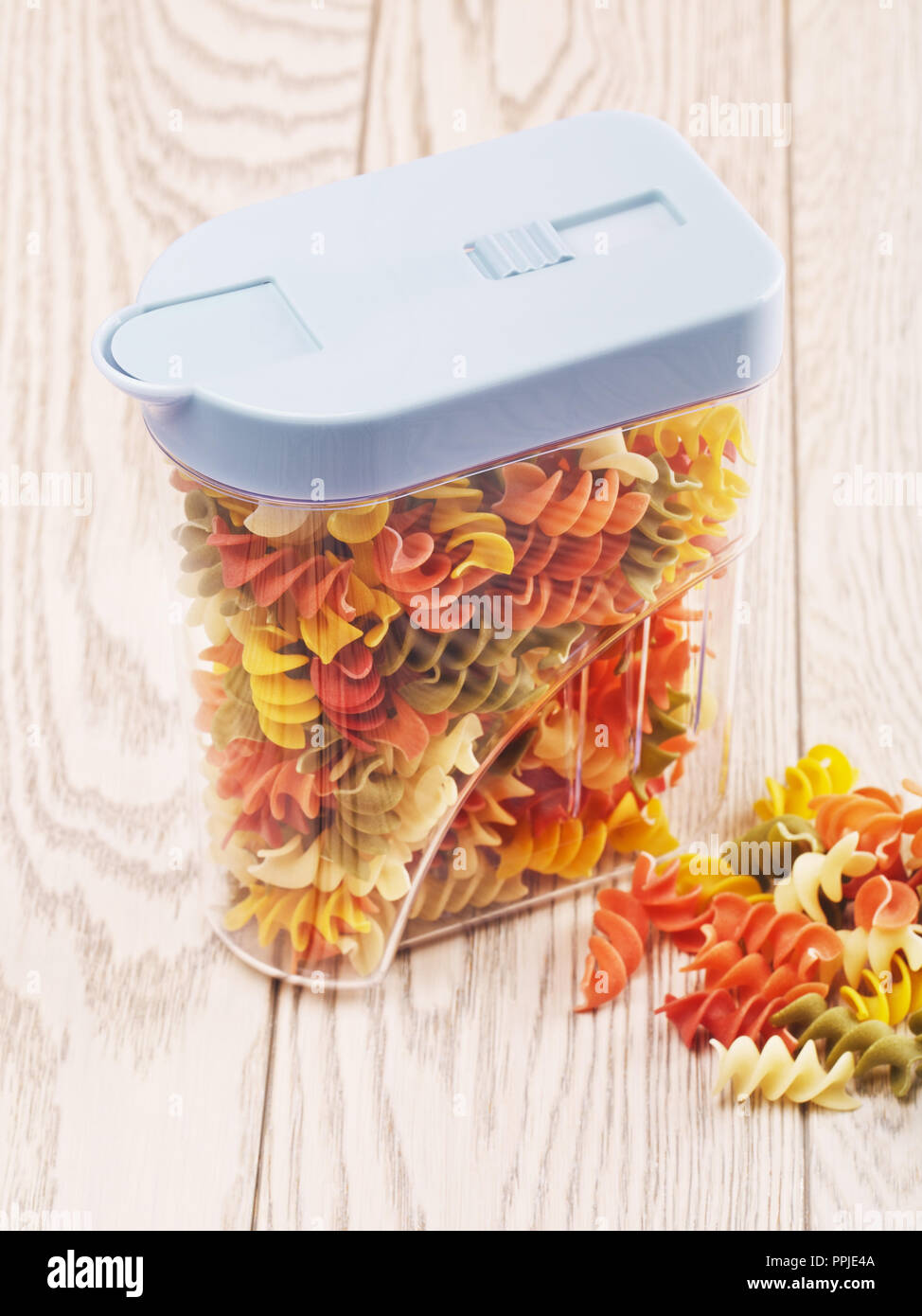 raw spiral pasta of different color in plastic container Stock Photo ...