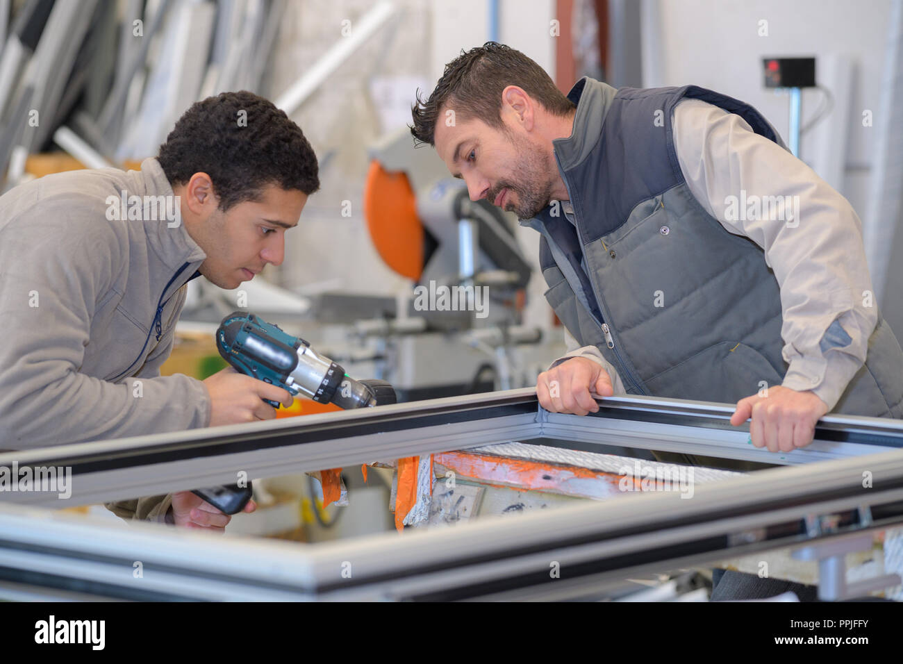 Worker using electric drill on window frame Stock Photo - Alamy