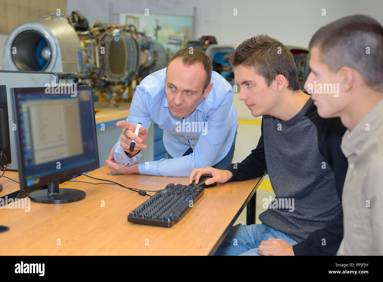 Teacher with students pointing to computer Stock Photo - Alamy