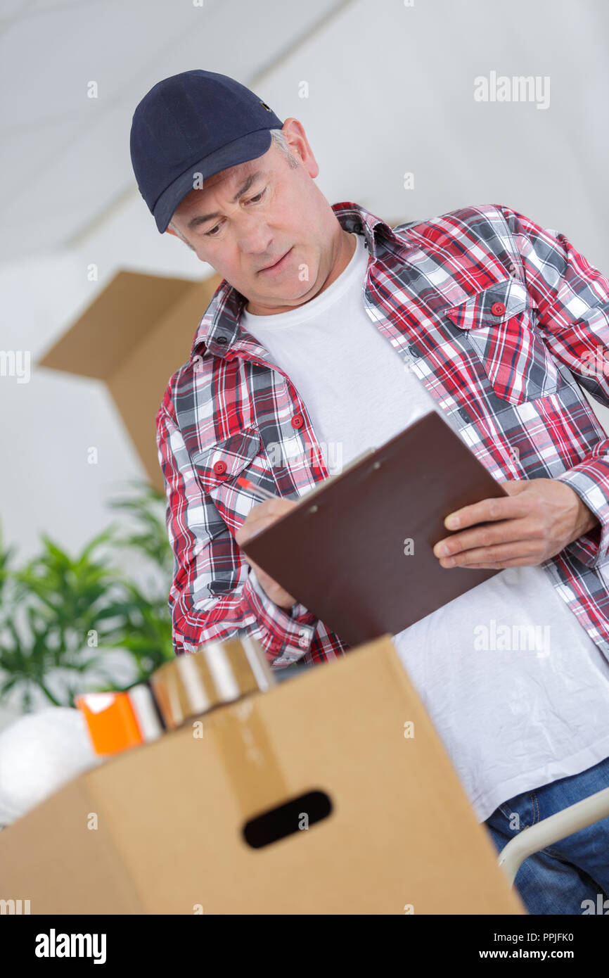 man signing for the delivery of boxes Stock Photo - Alamy