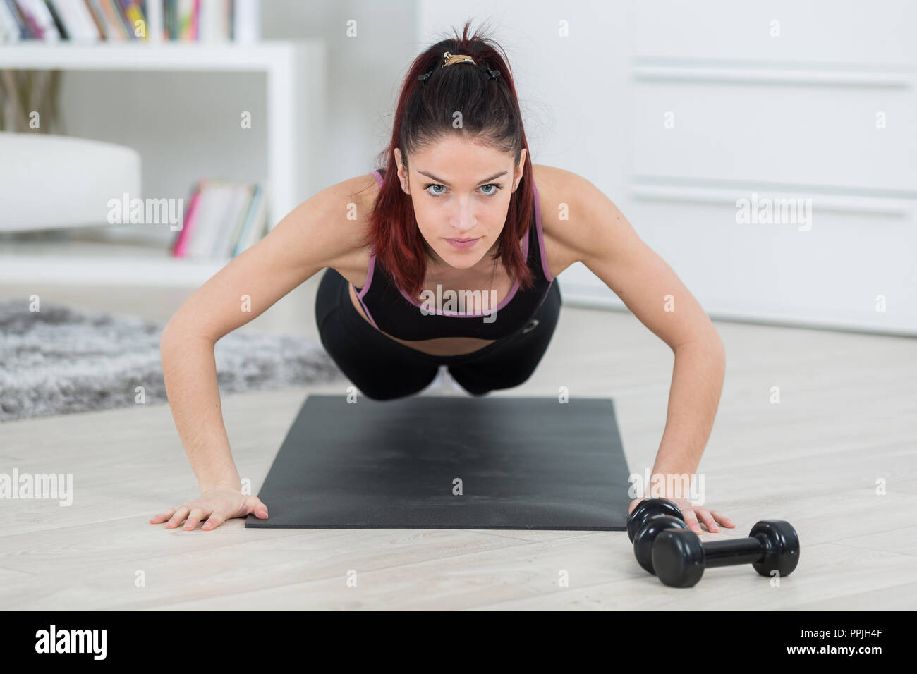 Front view of woman in plank position Stock Photo - Alamy