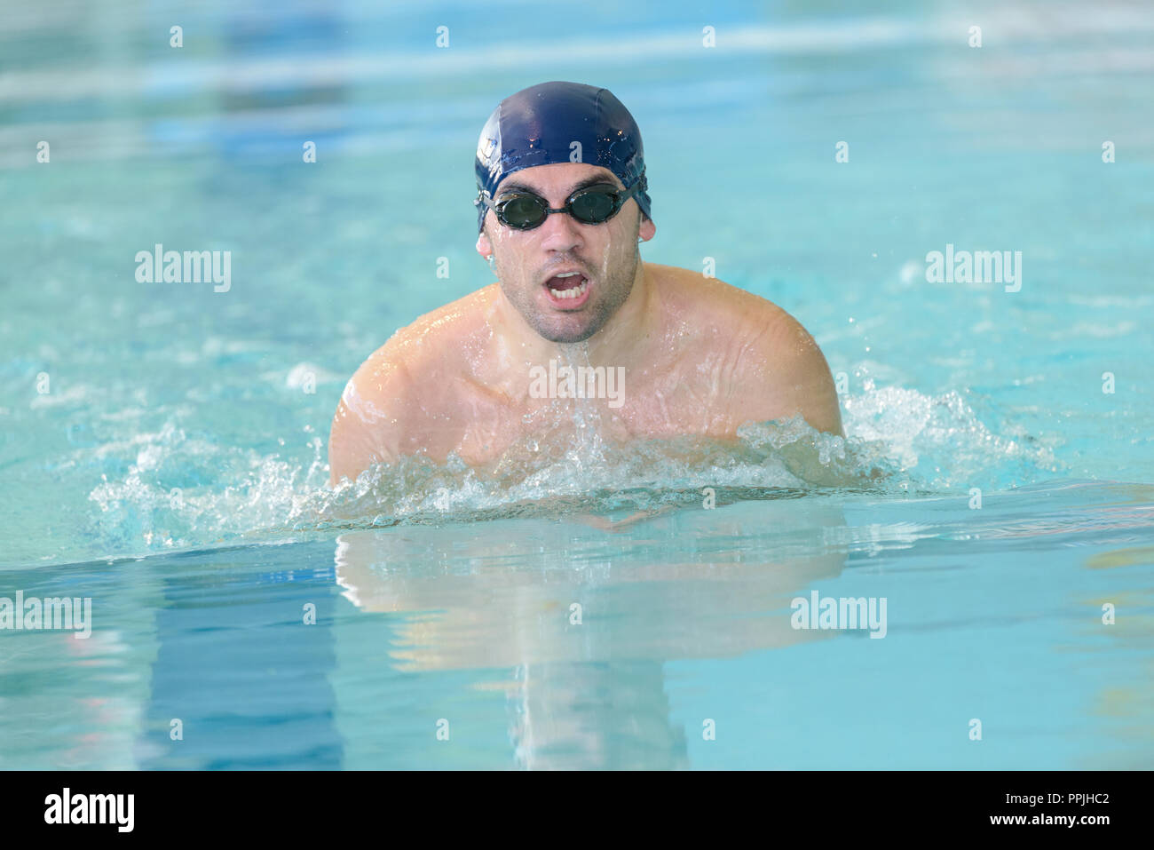 young healthy man with muscular body swims in swimming pool Stock Photo ...