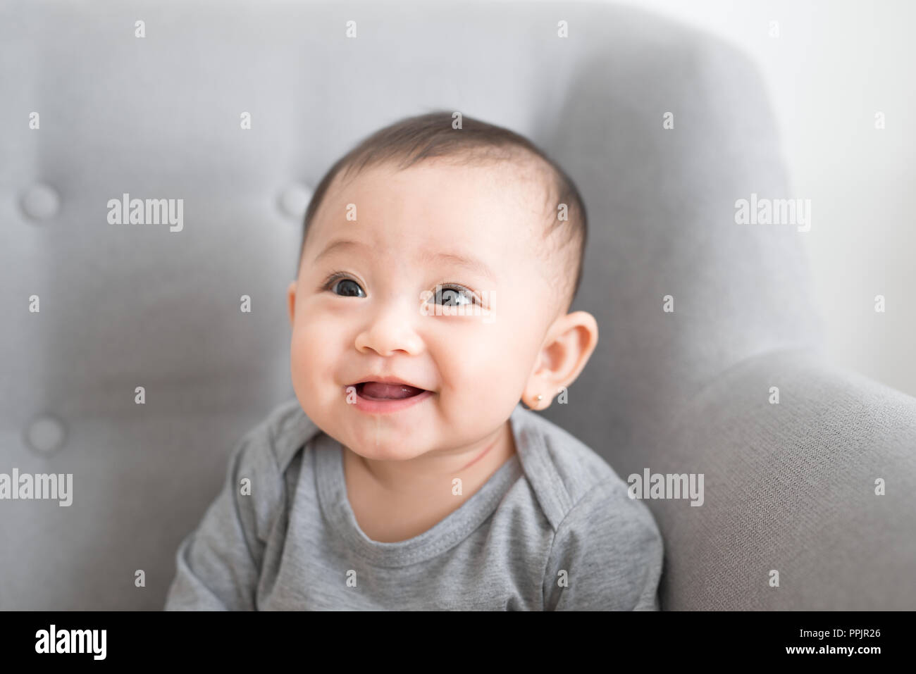 Cute little baby playing at home in gray room Stock Photo - Alamy