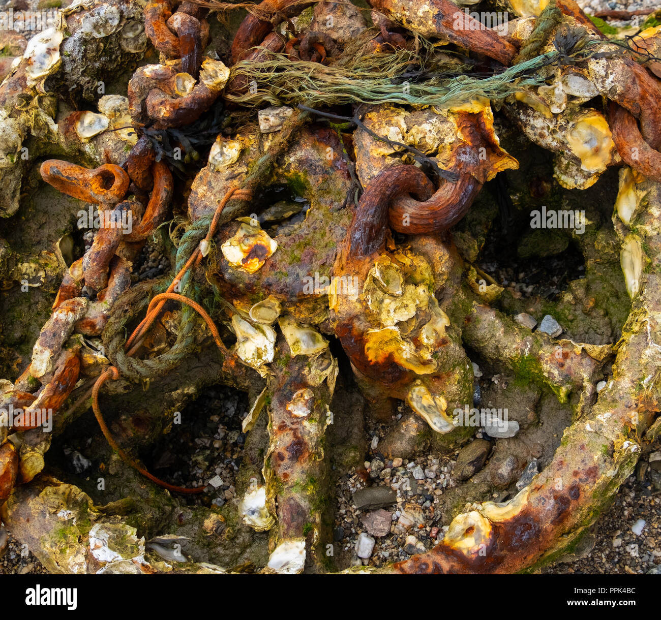 Remains of old metal wheel and chains corroded and rusted by age and ...