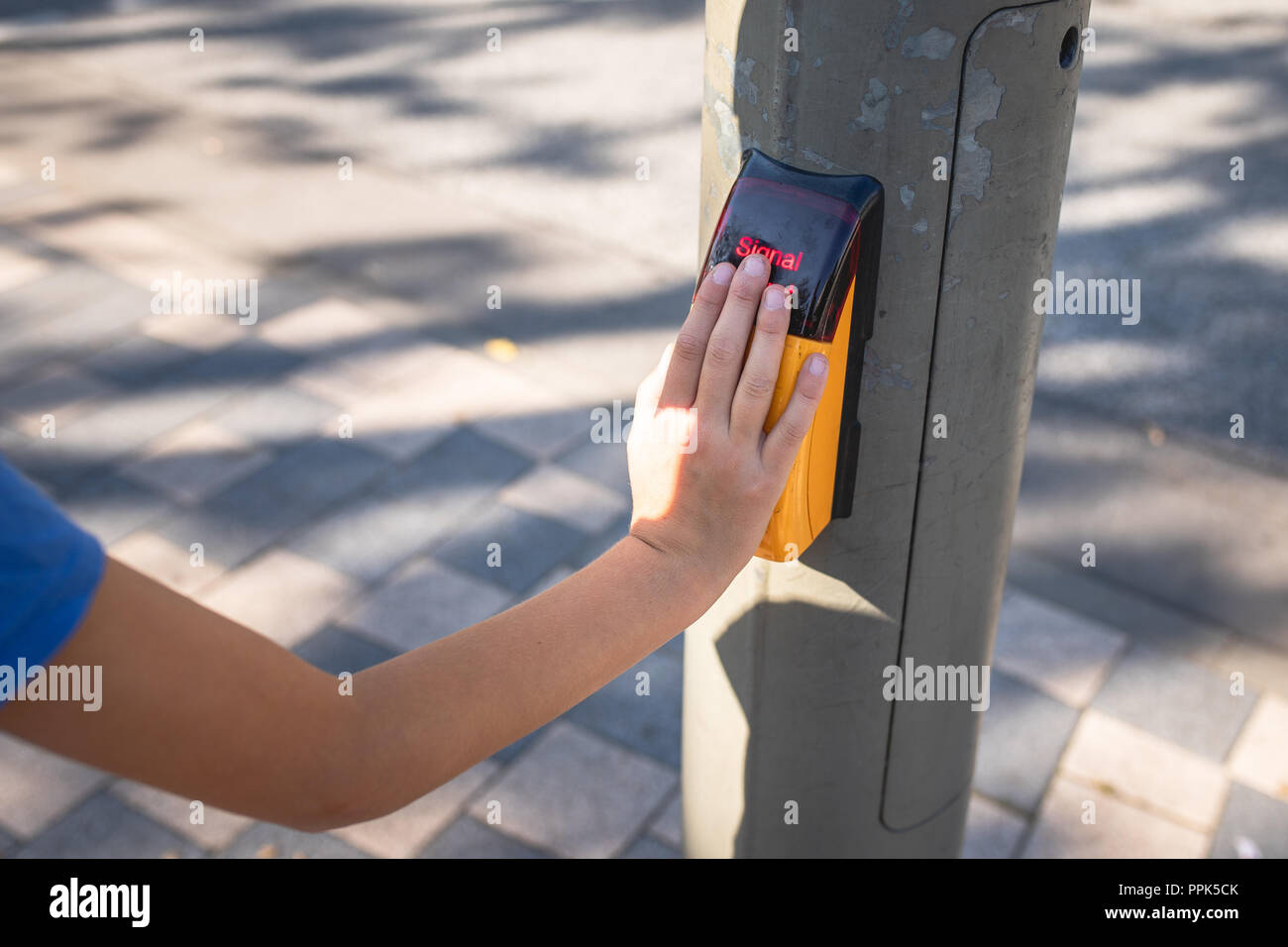 Close-up of a child's hand on the capacitive push button of a ...