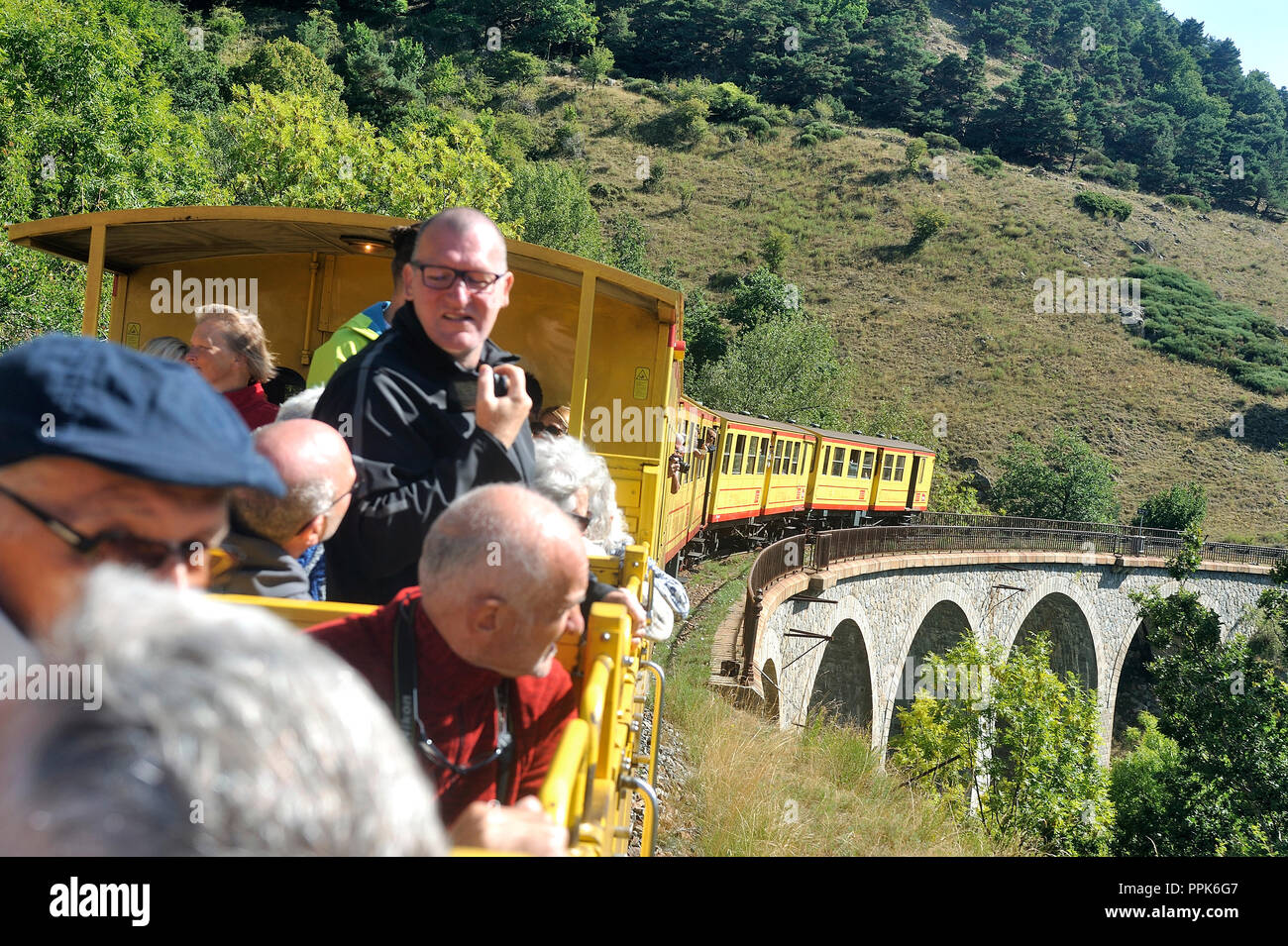 The small yellow trains of the Pyrenees crossing a beautiful mountain ...