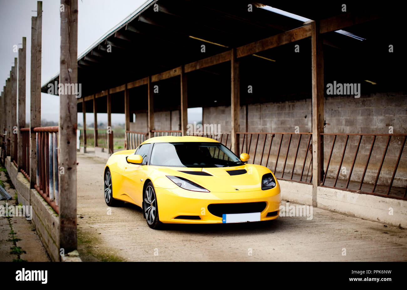 Bright yellow Lotus Evora in a farmyard in the Cotswolds, England, UK ...