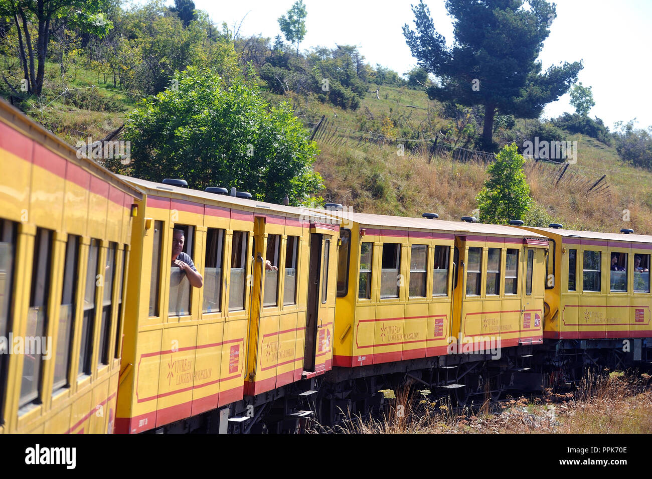 The small yellow trains of the Pyrenees crossing a beautiful mountain ...