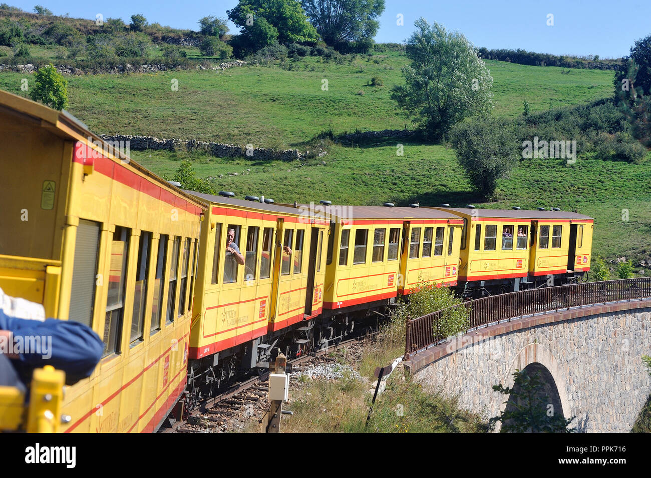 The small yellow trains of the Pyrenees crossing a beautiful mountain ...