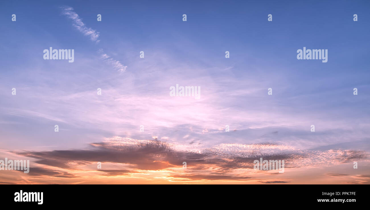 Pastel colored sunset sky panoramic view. Sun into clouds at golden ...