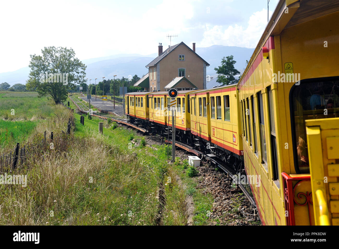 The small yellow train of the Pyrenees crossing a beautiful mountain ...