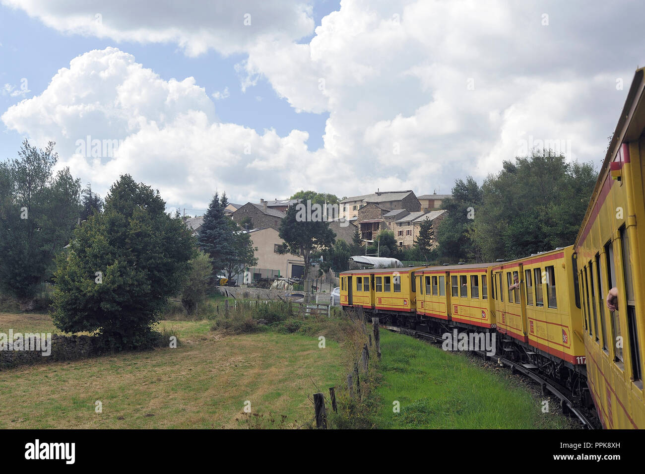 The small yellow train of the Pyrenees crossing a beautiful mountain ...