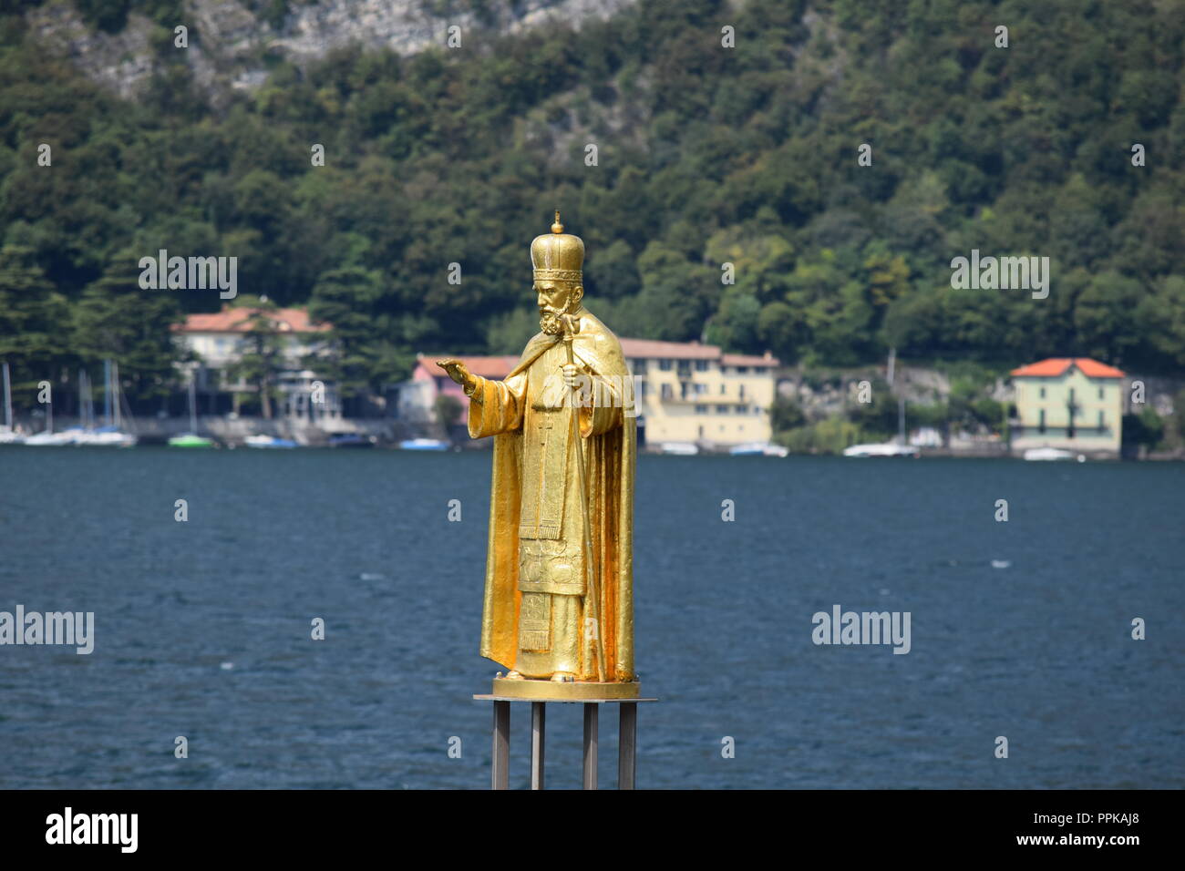 Golden statue of St. Nicholas in Lecco bay, Lake Como, Italy Stock ...