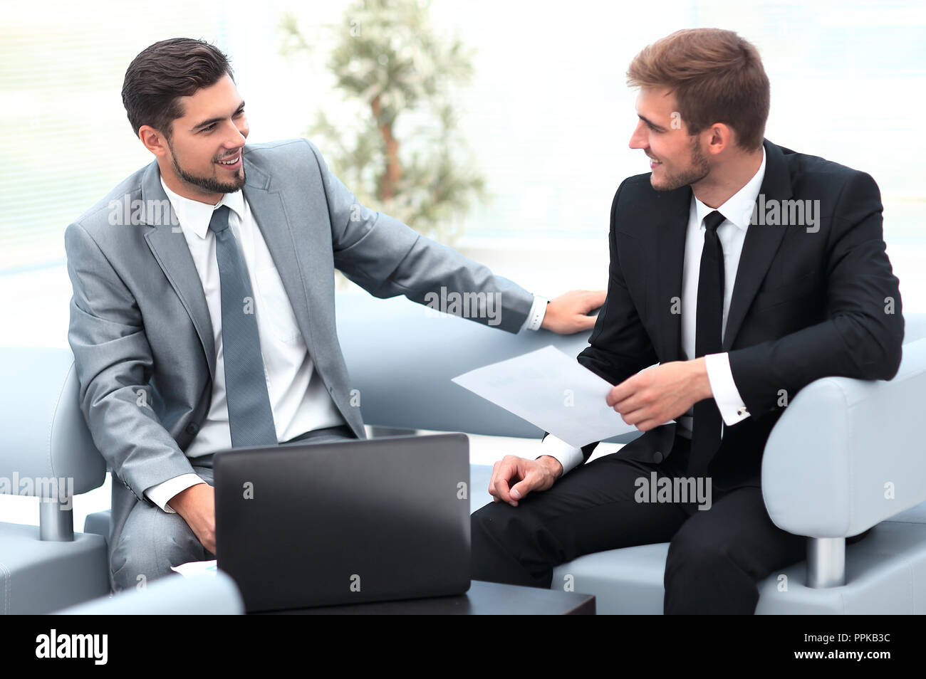 employees talking, sitting the lobby of the office Stock Photo - Alamy