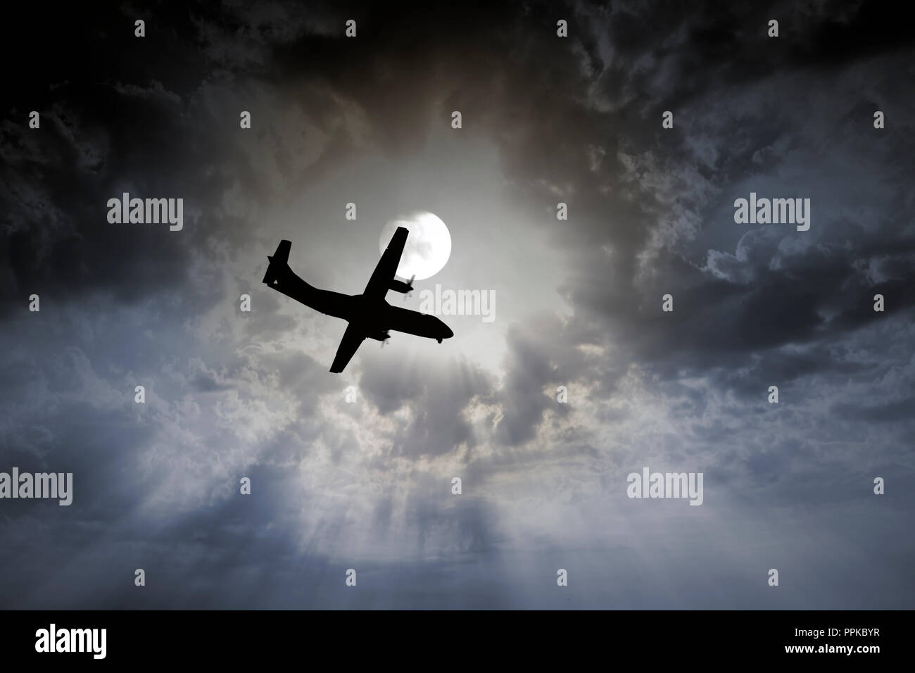 Flight of a propeller plane in a full moon night with clouds and rays ...