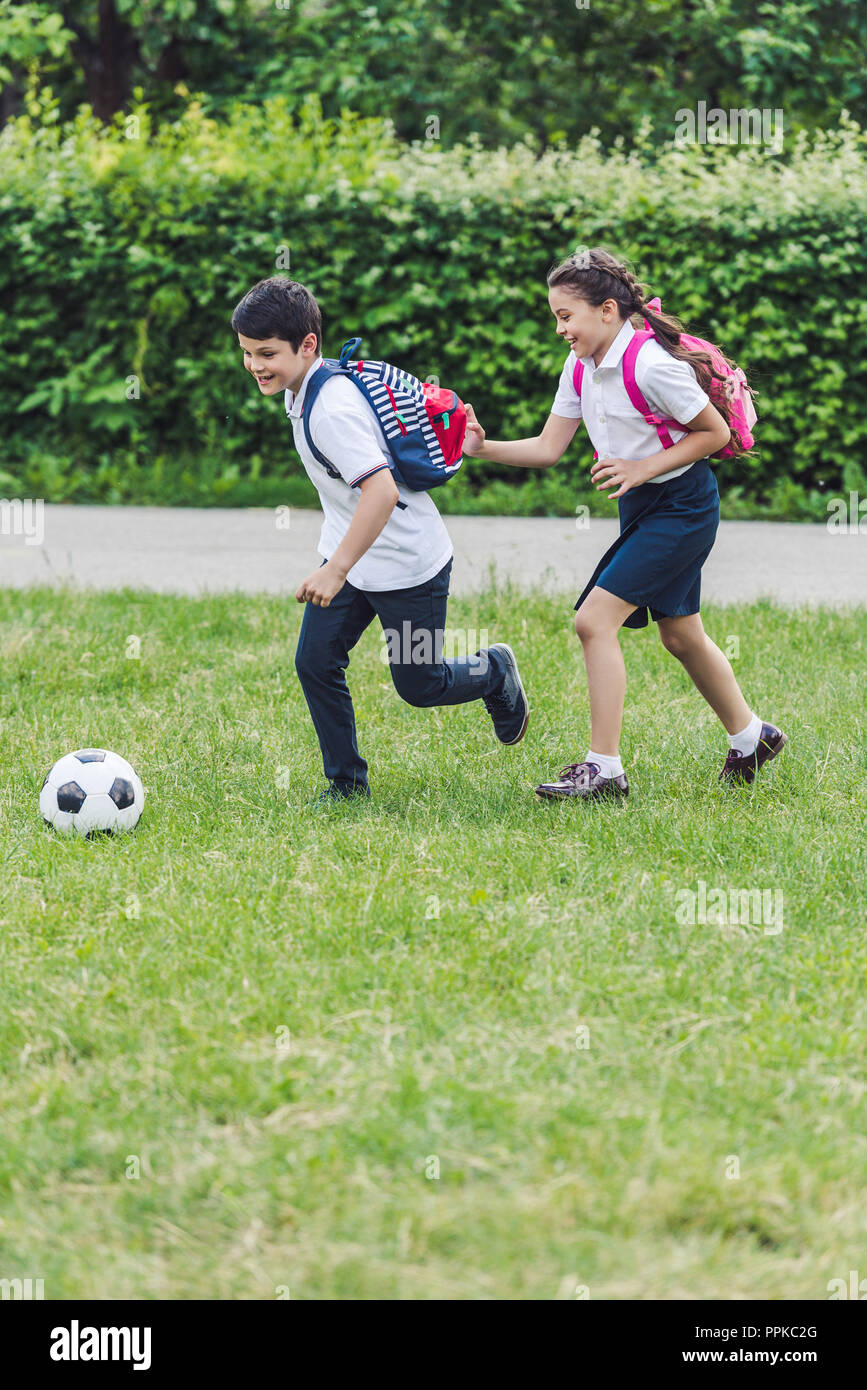 active schoolchildren playing soccer together on meadow in park Stock ...