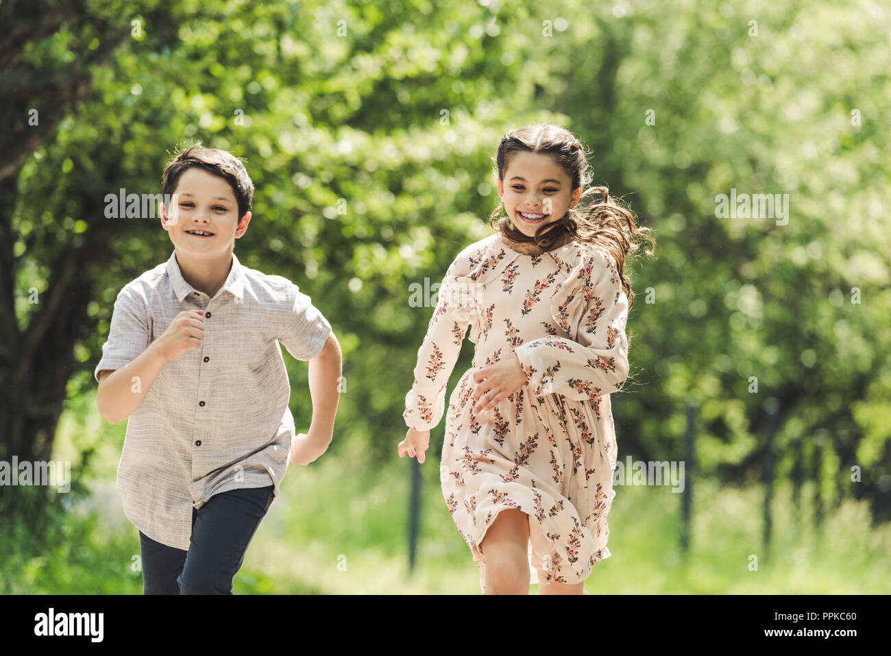smiling kids having fun and running in summer park Stock Photo - Alamy