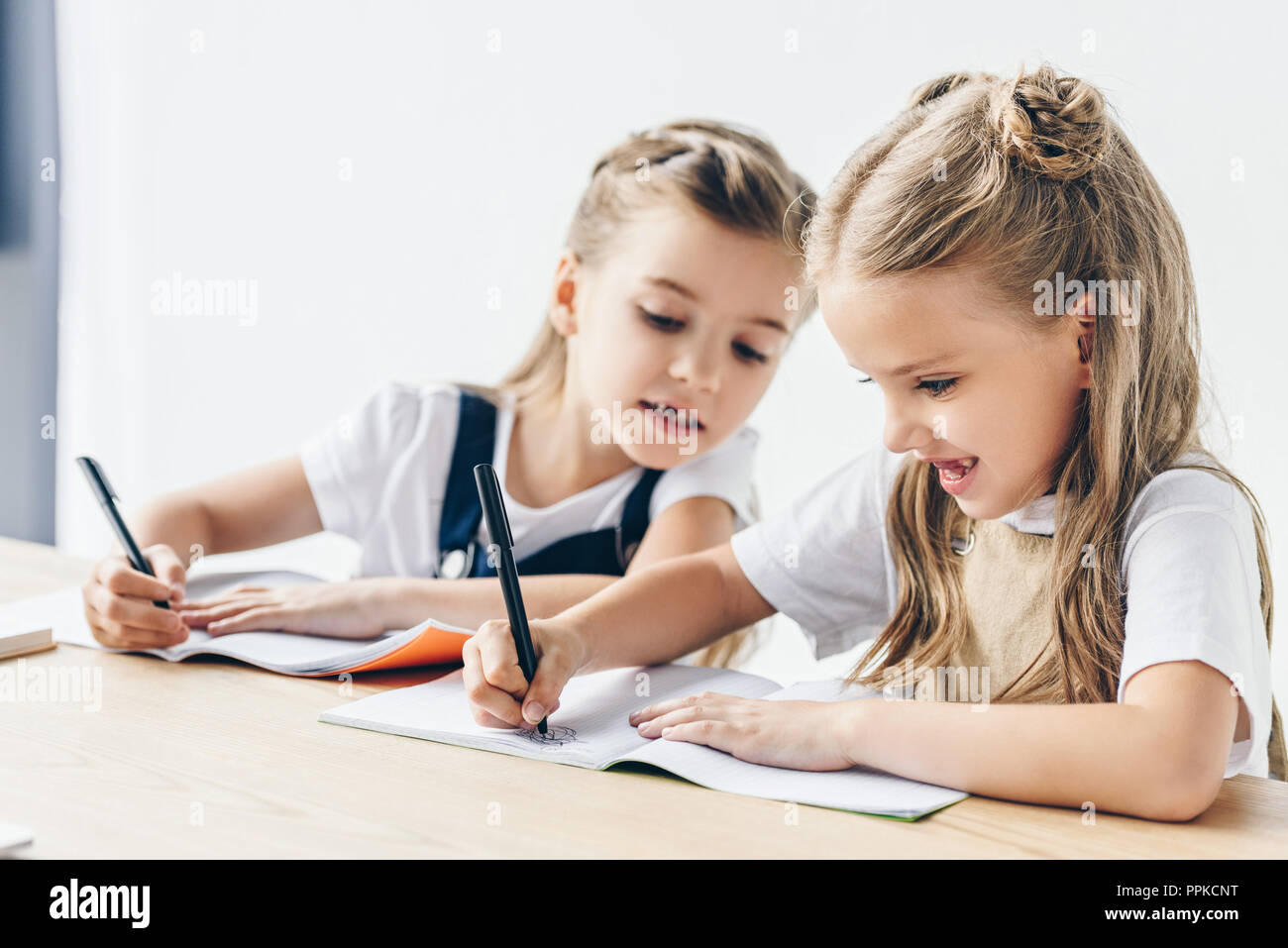 little schoolgirl cheating and copying work of her classmate isolated ...