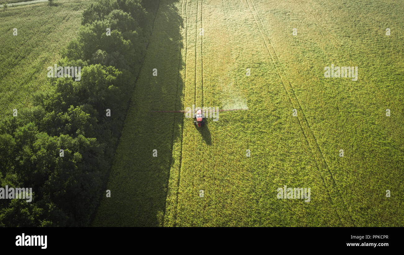 Agricultural machinery in the field. Tractor with a sprayer. Aerial ...