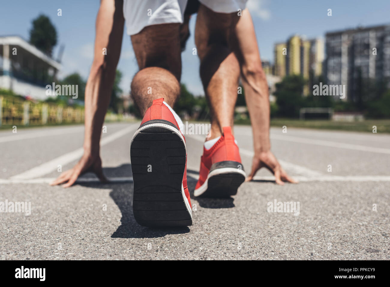 back view of male sprinter in starting position on running track Stock ...
