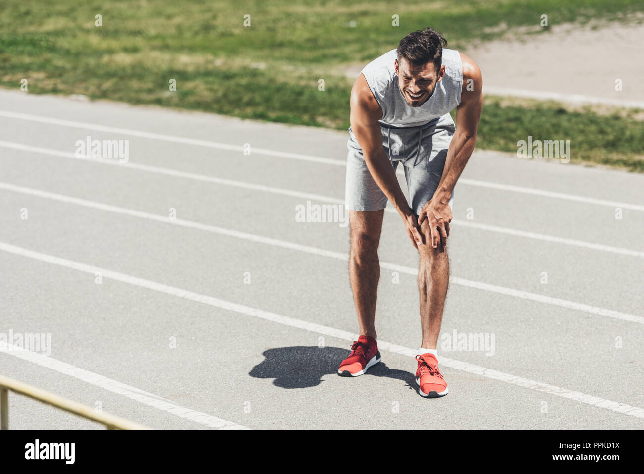 suffering young runner with leg injury standing on running track Stock ...