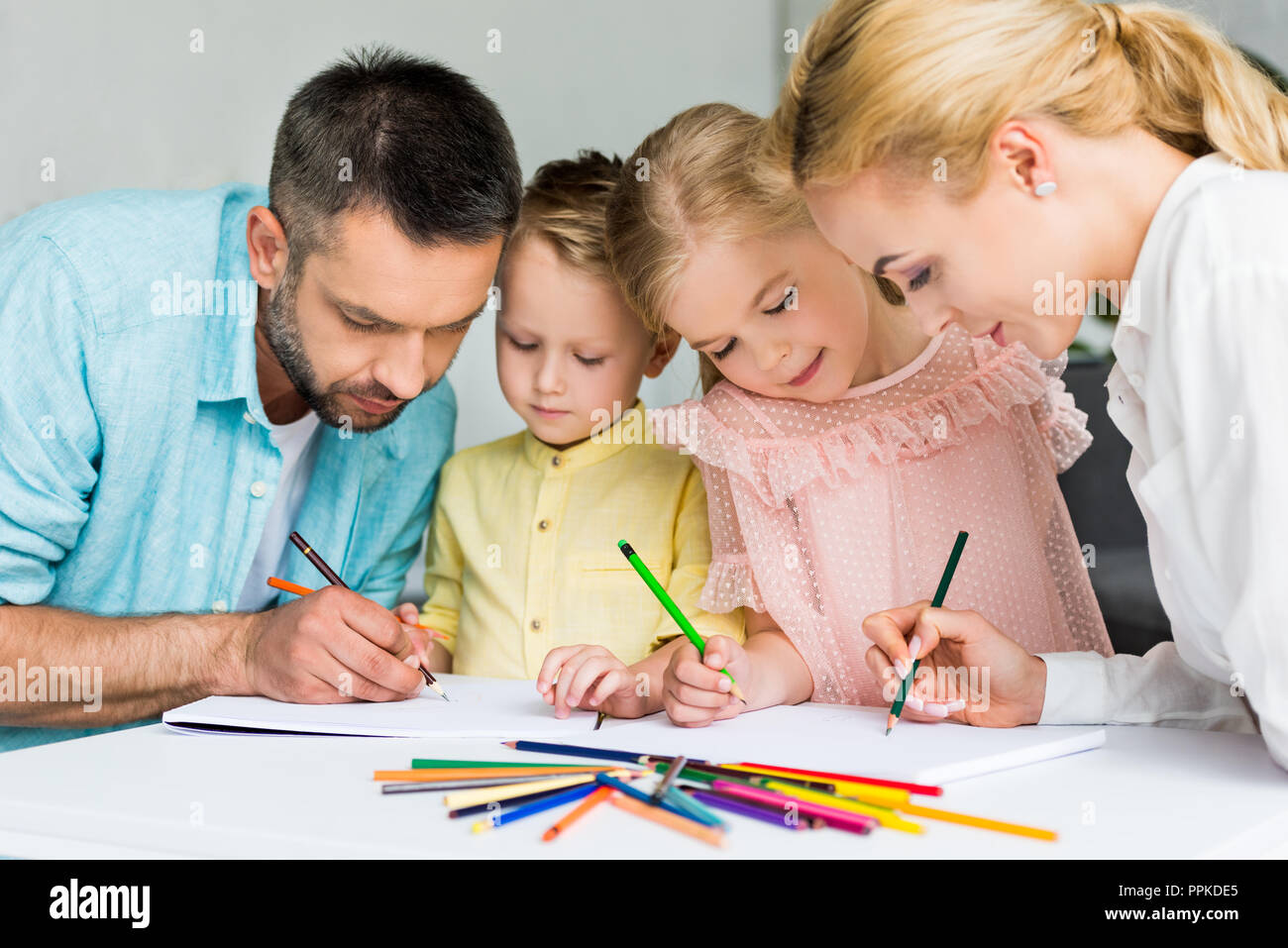 happy family drawing with colored pencils together at home Stock Photo ...