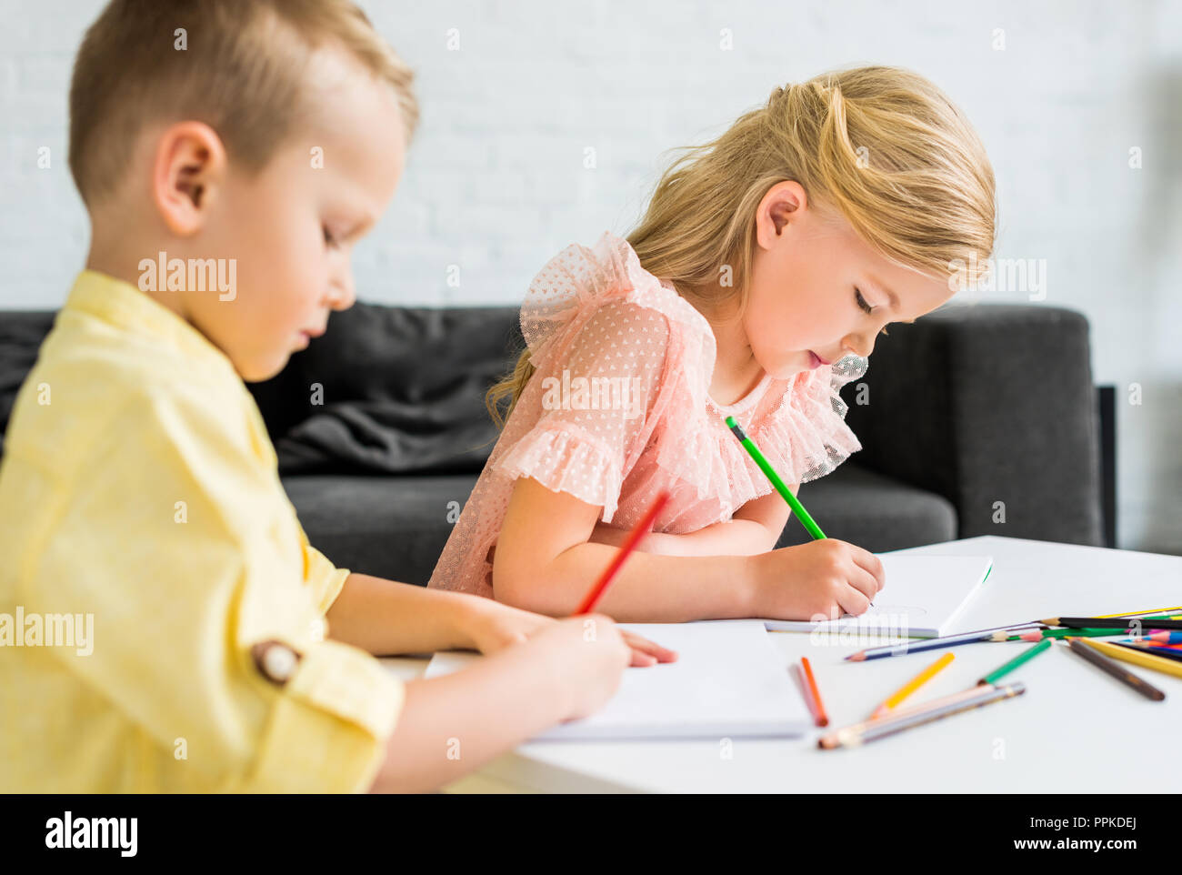 adorable little kids drawing with colored pencils at home Stock Photo ...