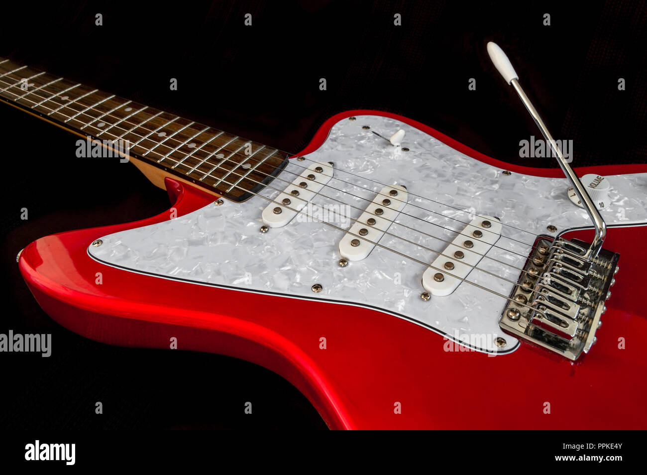 Beautiful red electric guitar isolated on black background. String ...