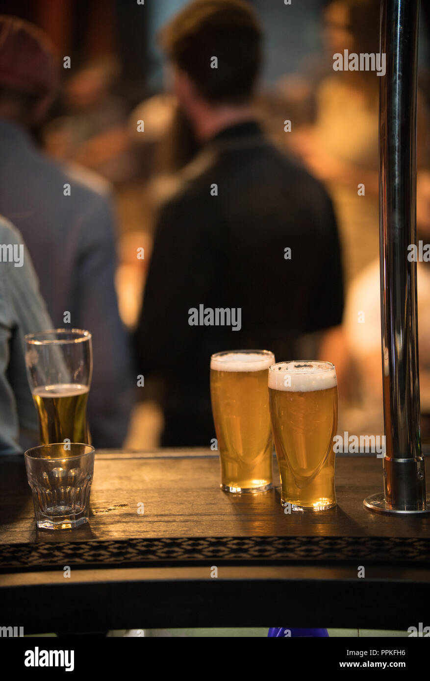 Mugs with beer and a glass of alcohol stand on the table on the ...