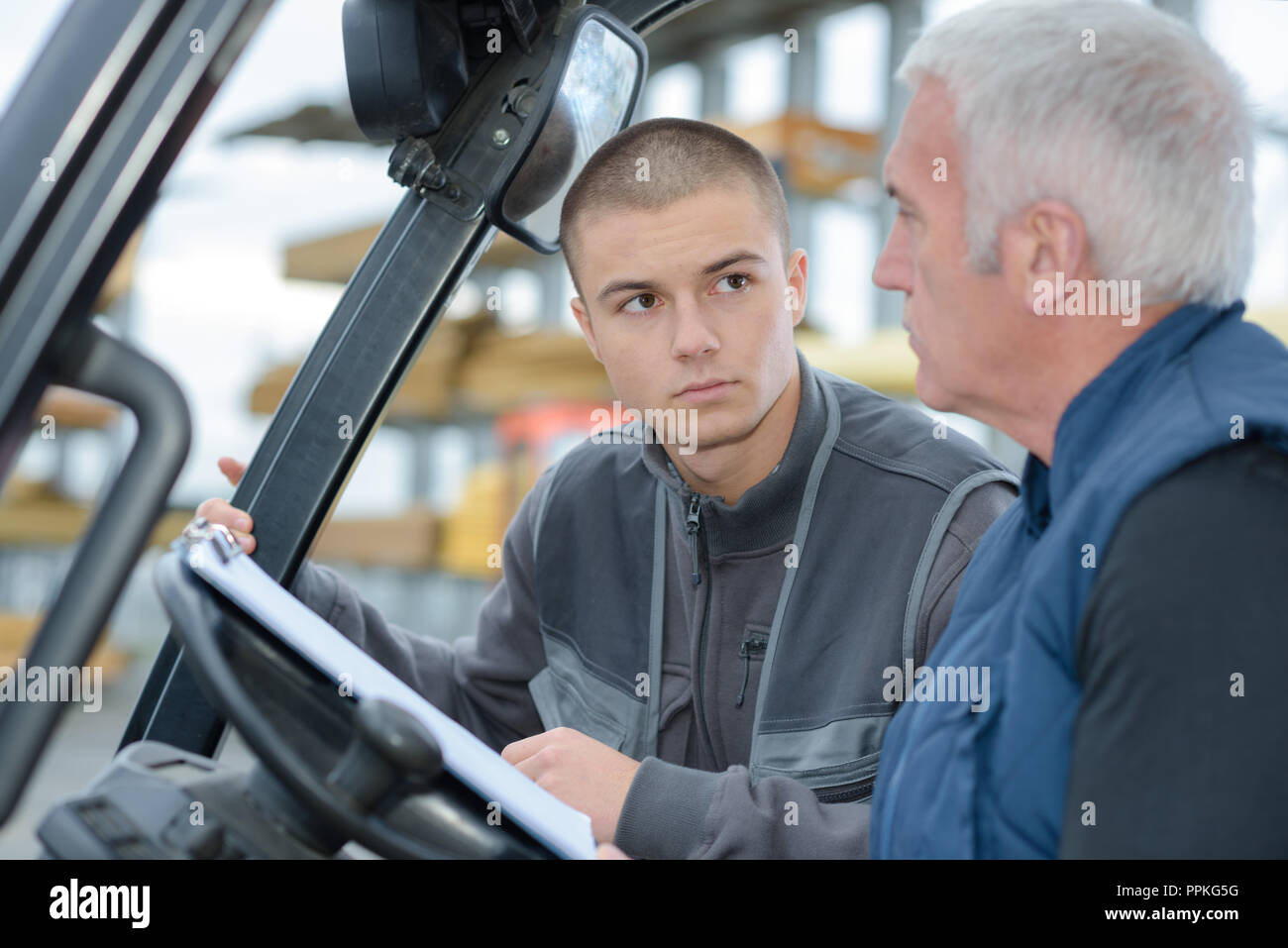 forklift driver in industrial logistics warehouse with co-worker Stock ...