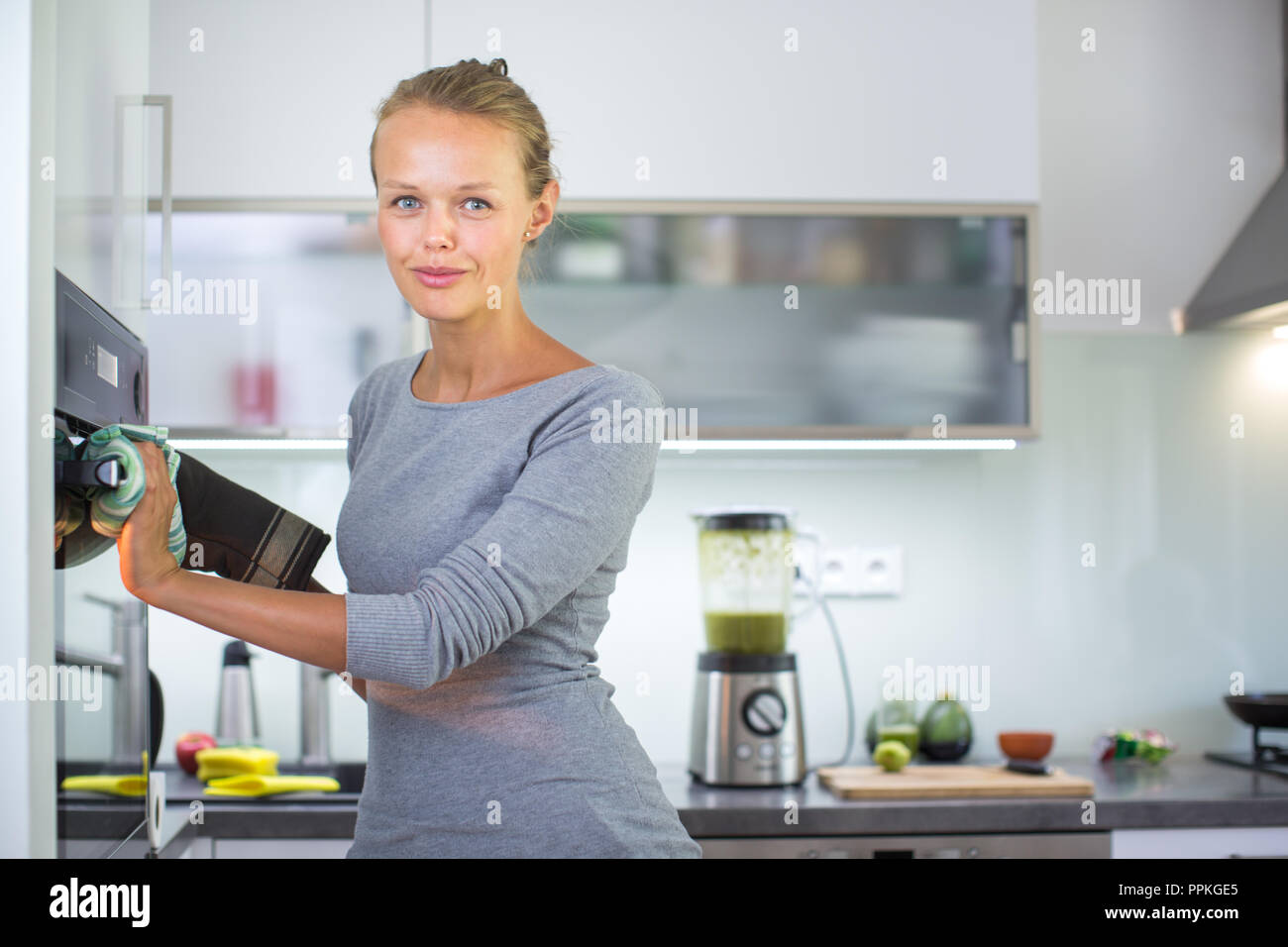 Pretty, young woman cooking in her modern kitchen Stock Photo - Alamy