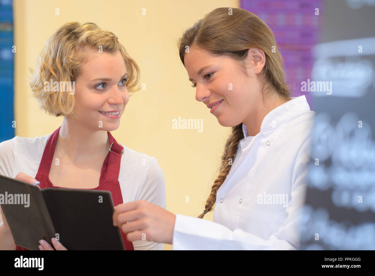 waiter and chef posing in front of the kitchen Stock Photo - Alamy
