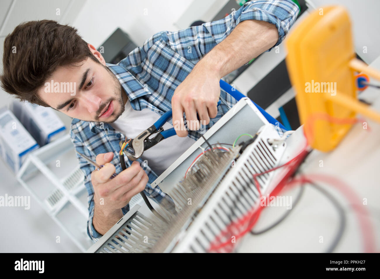man holding tools while fixing a device Stock Photo - Alamy