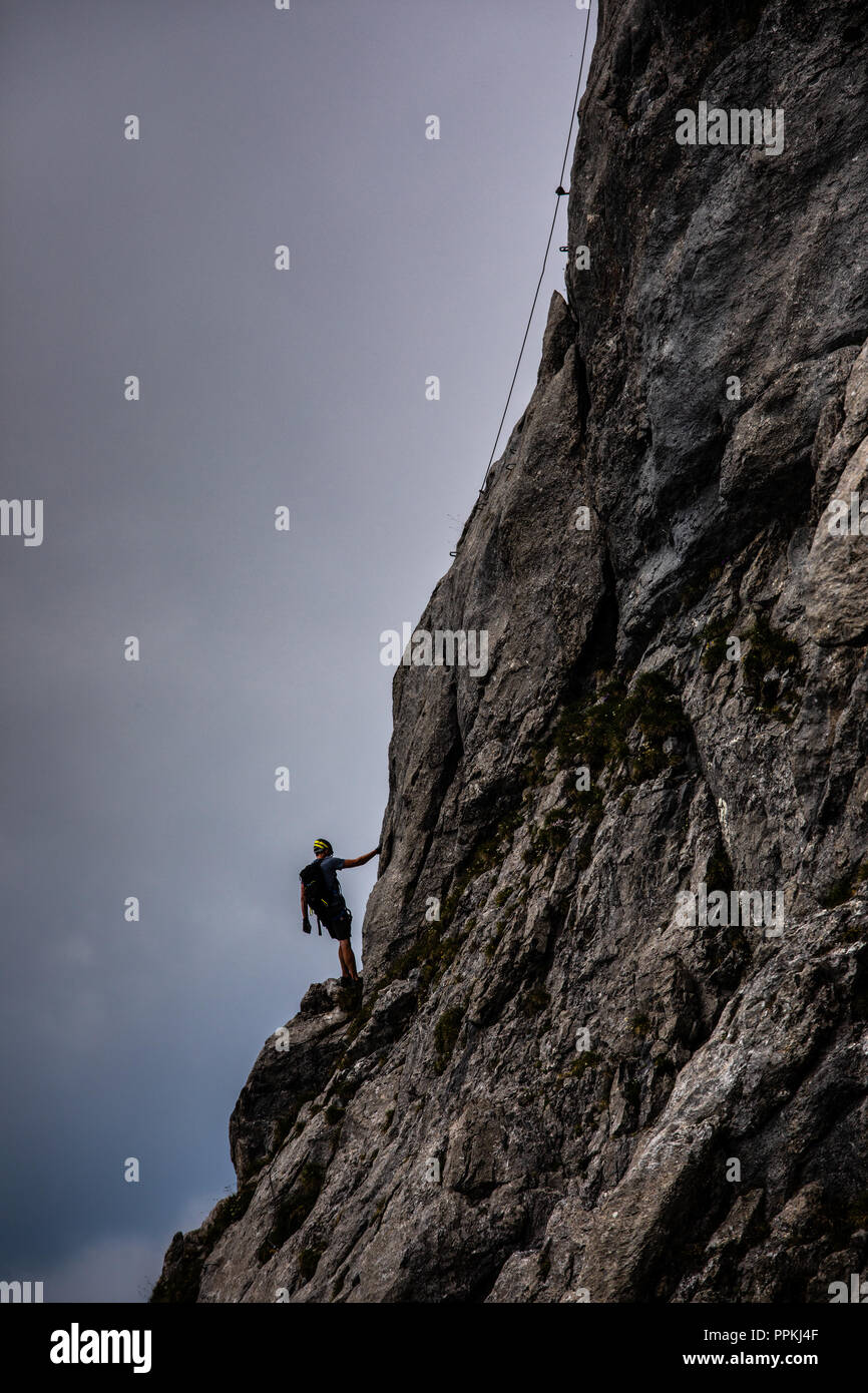Pretty, female climber on a via ferrata - climbing on a rock in Swiss ...