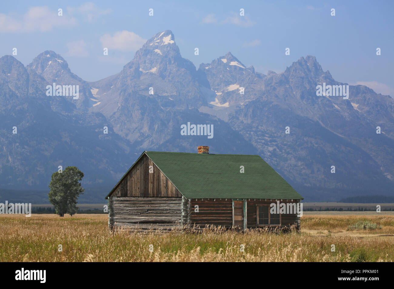 historic rustic farm building on prairie with spectacular mountains in ...