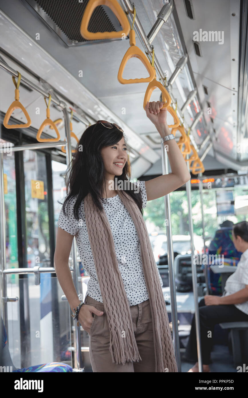 Beautiful young woman standing in bus Stock Photo - Alamy