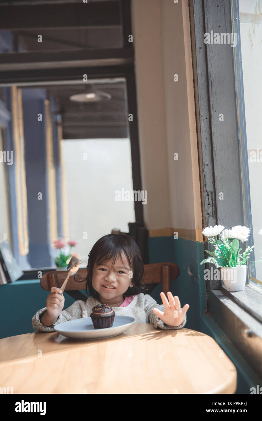 Happy little girl enjoy eating cake Stock Photo - Alamy