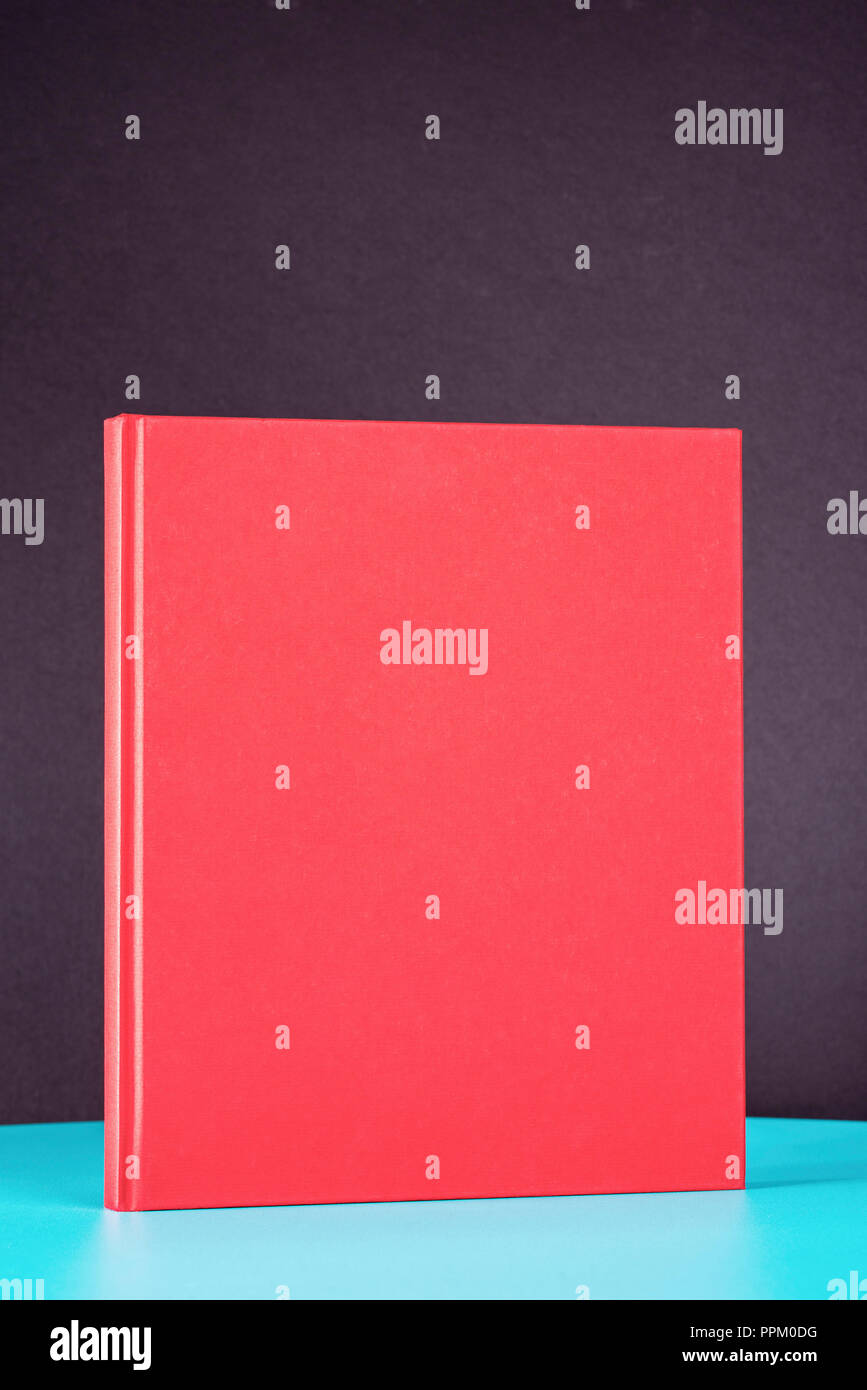 Red book on the green metal table. Black background Stock Photo - Alamy