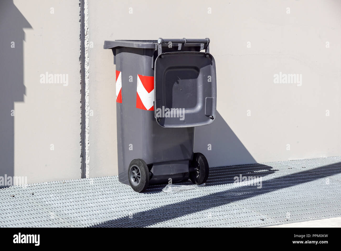 The photo shows old green bin with full garbages. It is a stinking bin ...