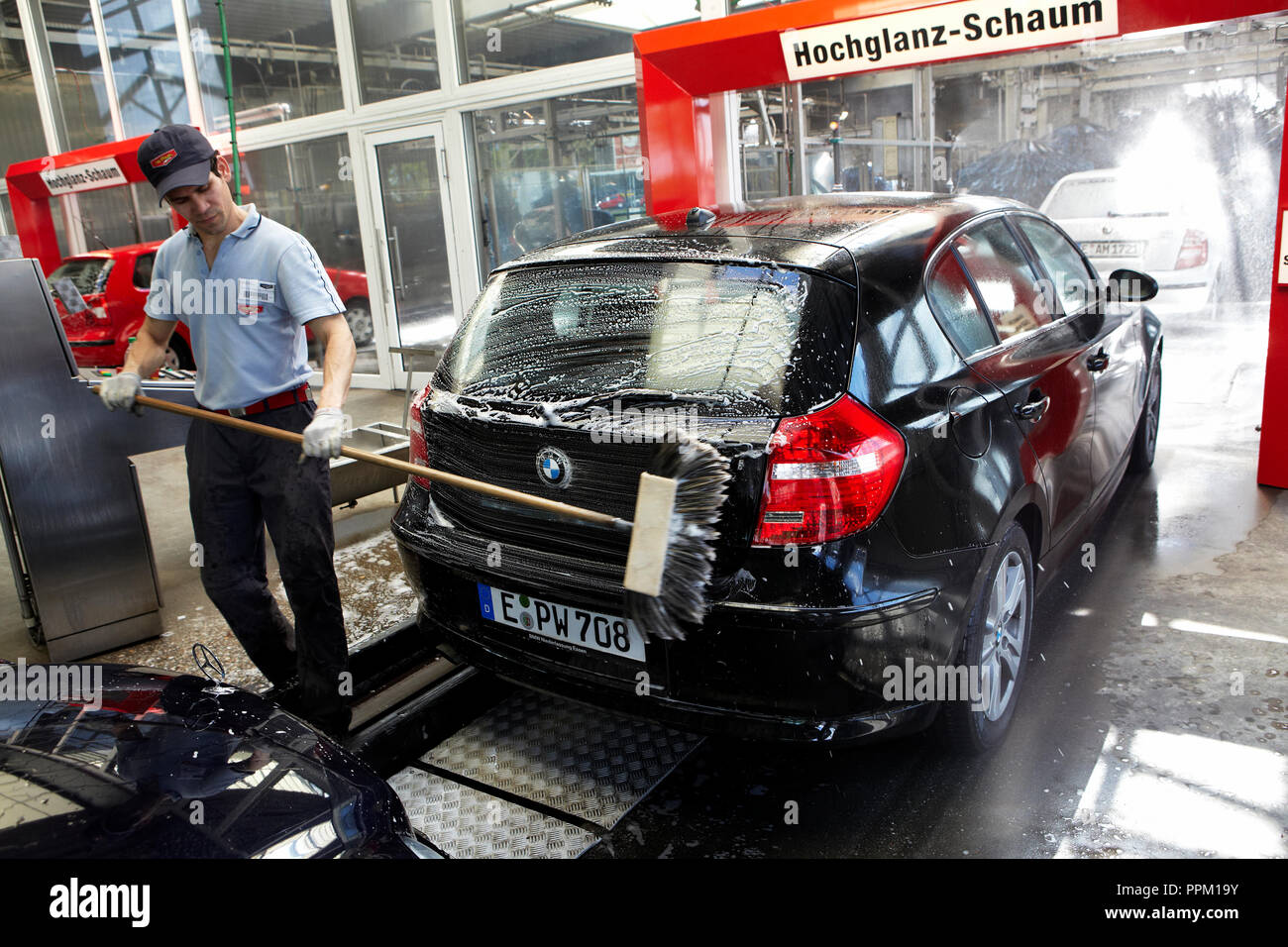 Cars are washed by brushes and various jets of water in the car wash at ...