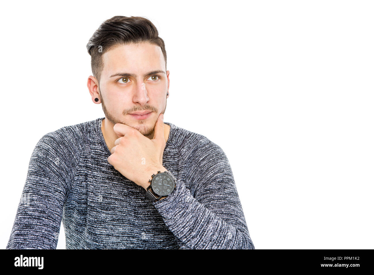 skeptical young modern brunette man with clock and hand an chin looks ...