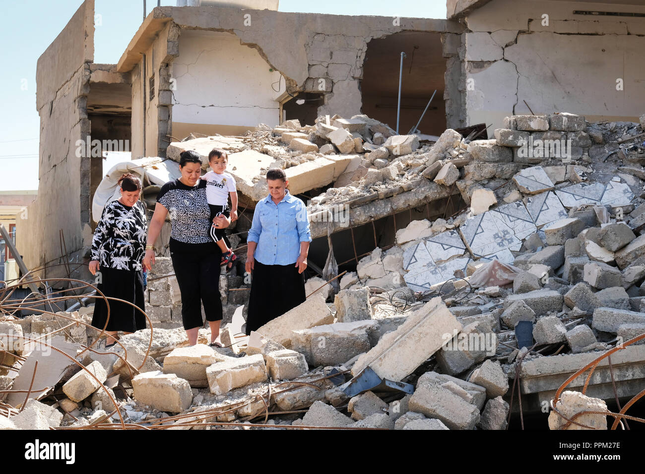 Family members in the rubble of a house destroyed by bombing in the war ...