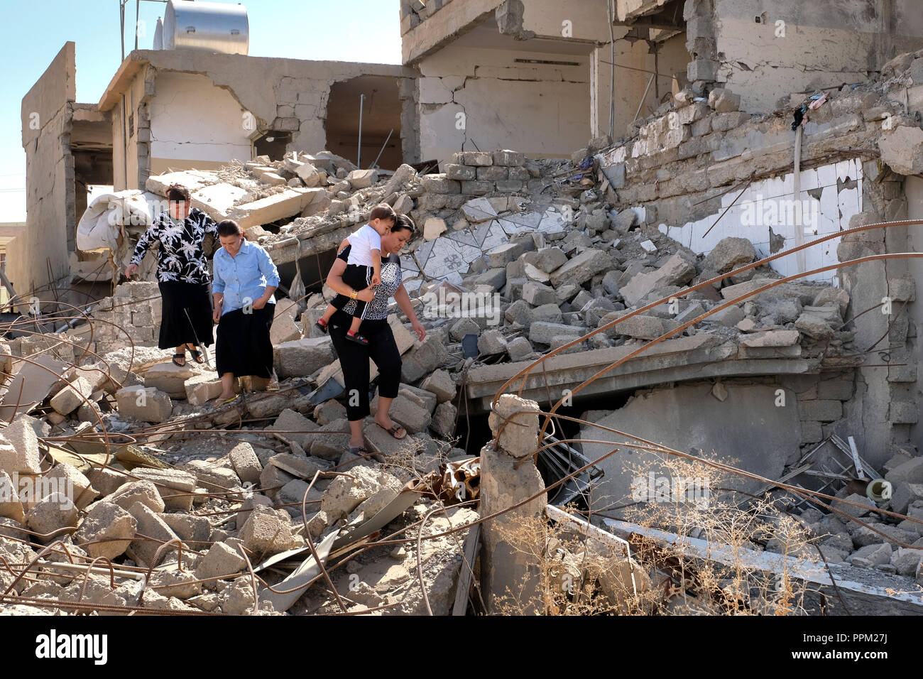 Family members in the rubble of a house destroyed by bombing in the war ...