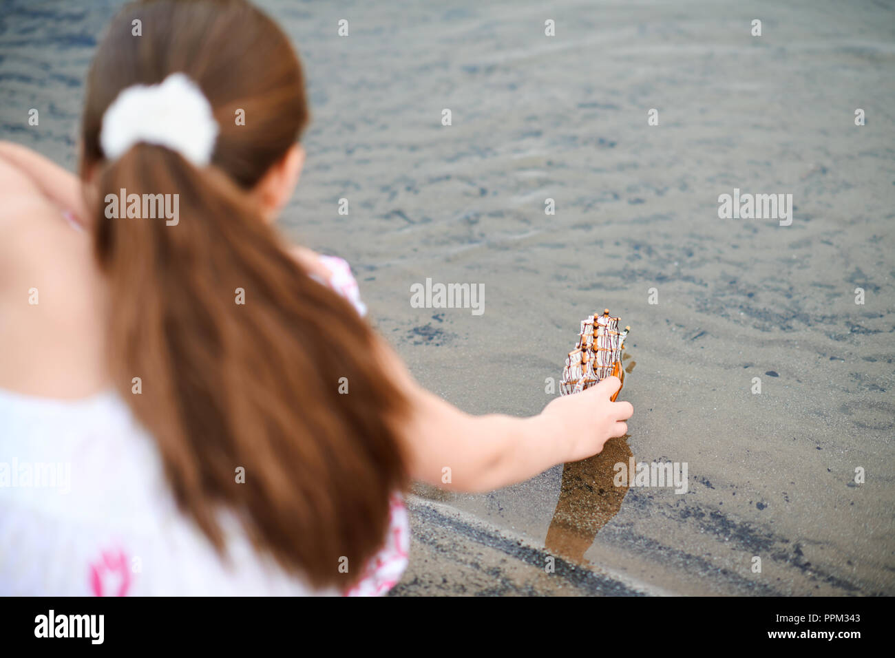 girl child playing with a toy sailing ship by the river Stock Photo - Alamy