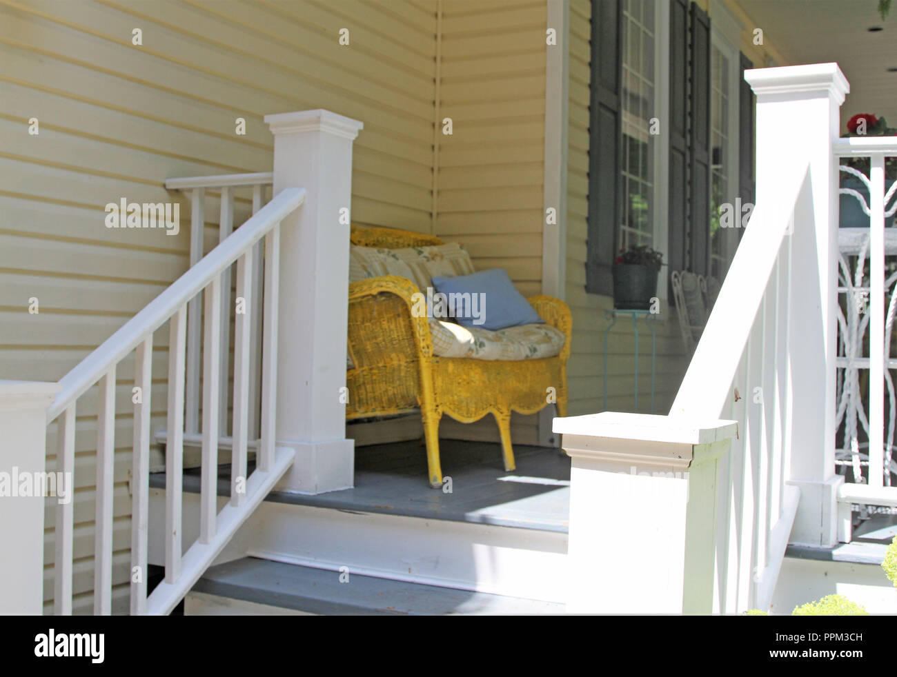 Yellow wicker sofa on a porch Stock Photo - Alamy